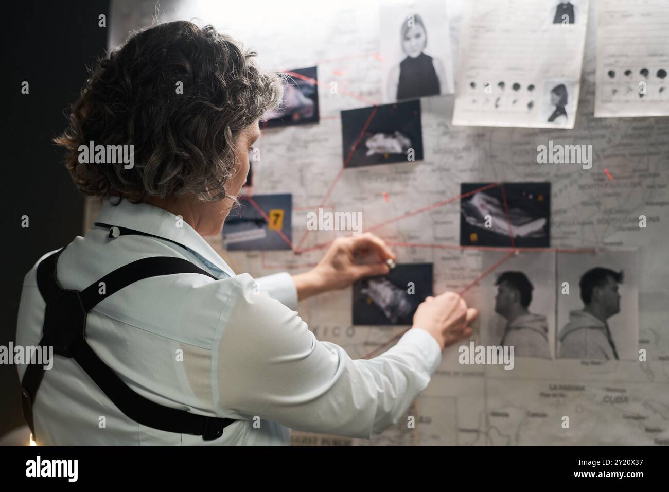 Focused on mapping out possible suspects and connections with red ...