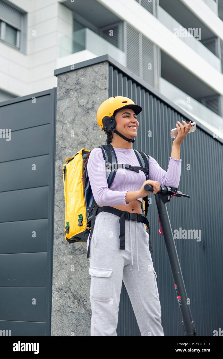 vertical smiling Latin food delivery girl, equipped with a yellow ...