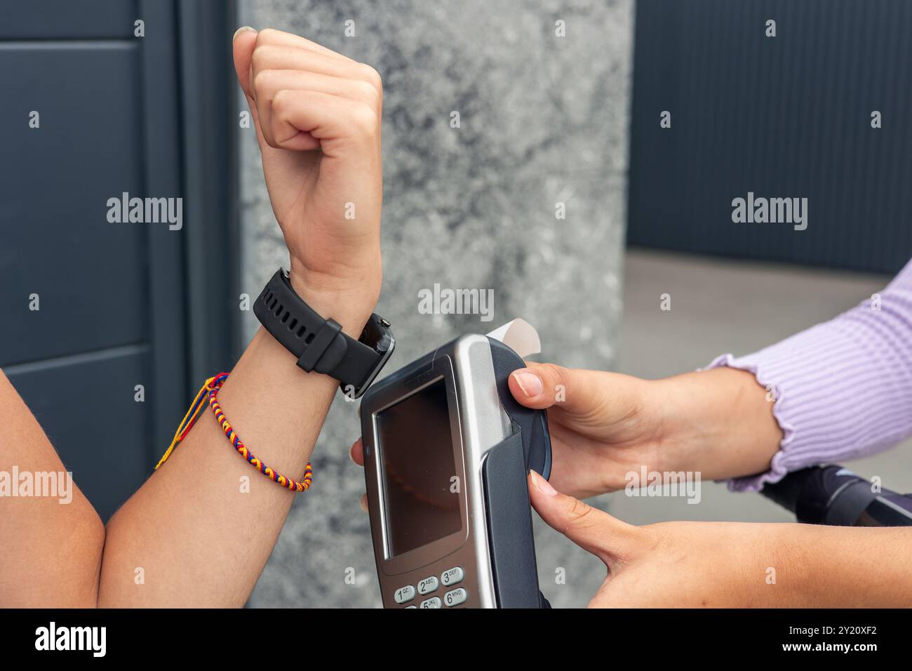 closeup delivery woman is holding a card reader as a customer uses ...