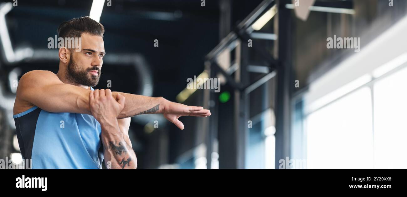 Man stretching in a gym during afternoon workout session Stock Photo ...