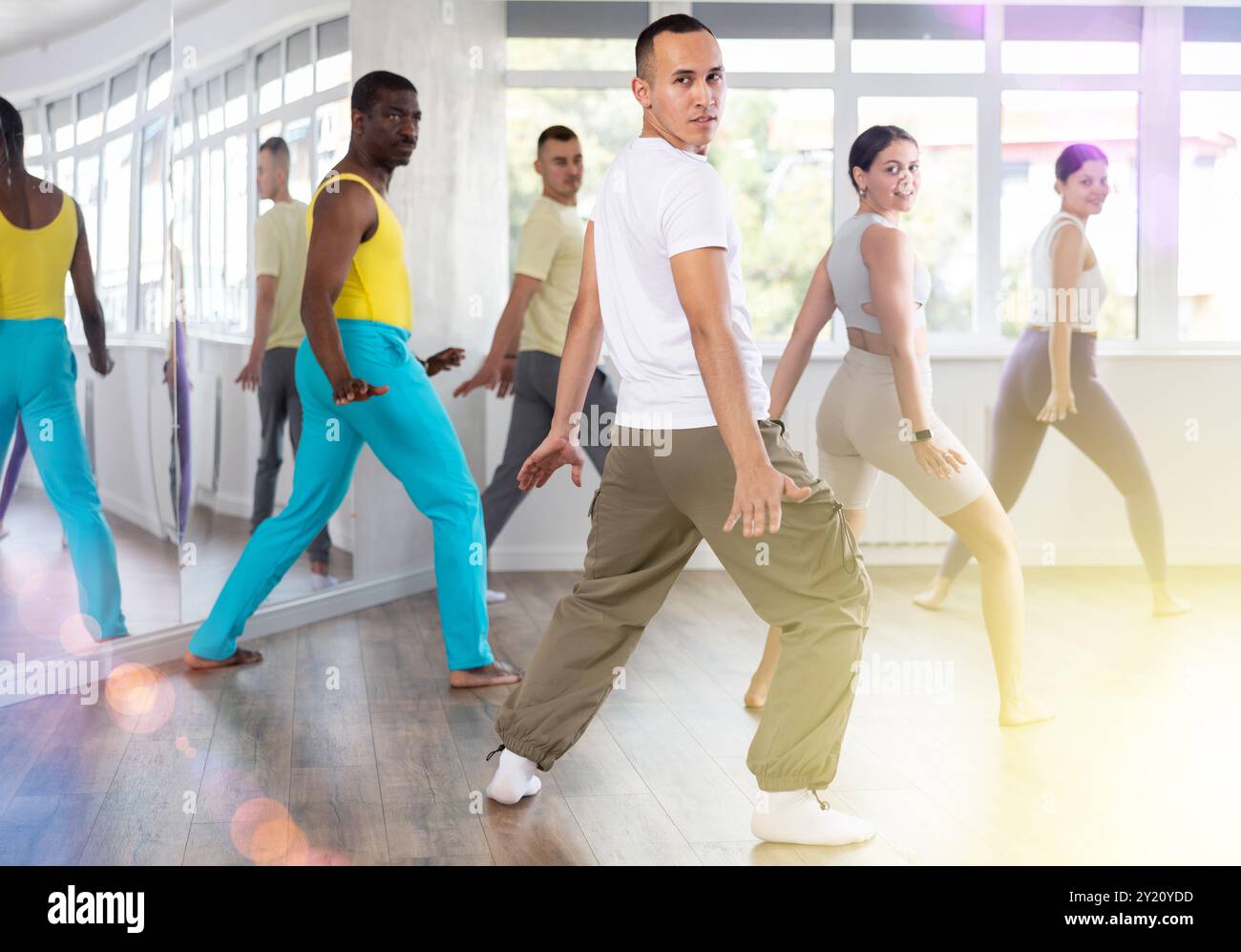 Happy multinational young man and woman dancing and training latin ...