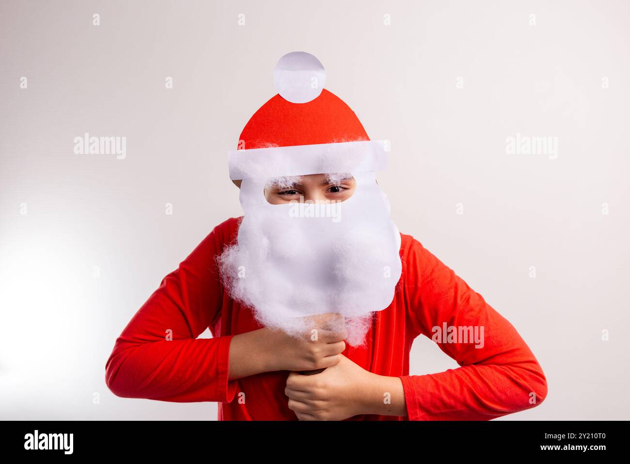 a little boy wearing a paper craft Santa hat and beard, disguise New ...