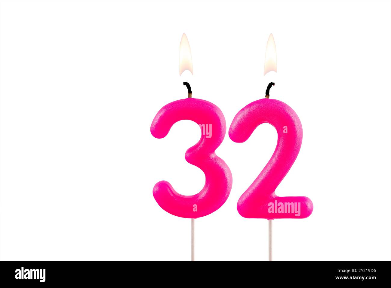 Pink number 32 birthday candle lit on white background Stock Photo - Alamy