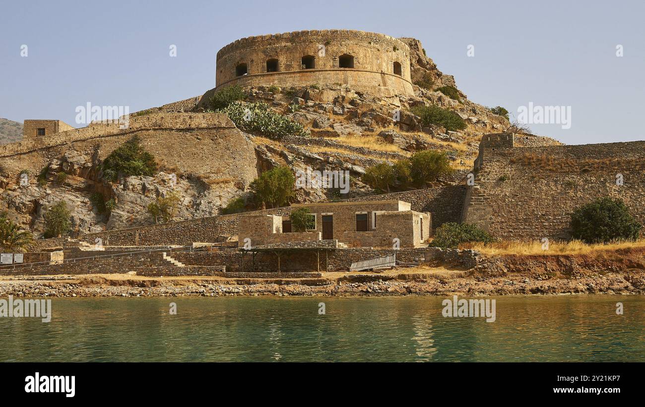 An ancient fortress with a round tower and walls surrounded by water ...