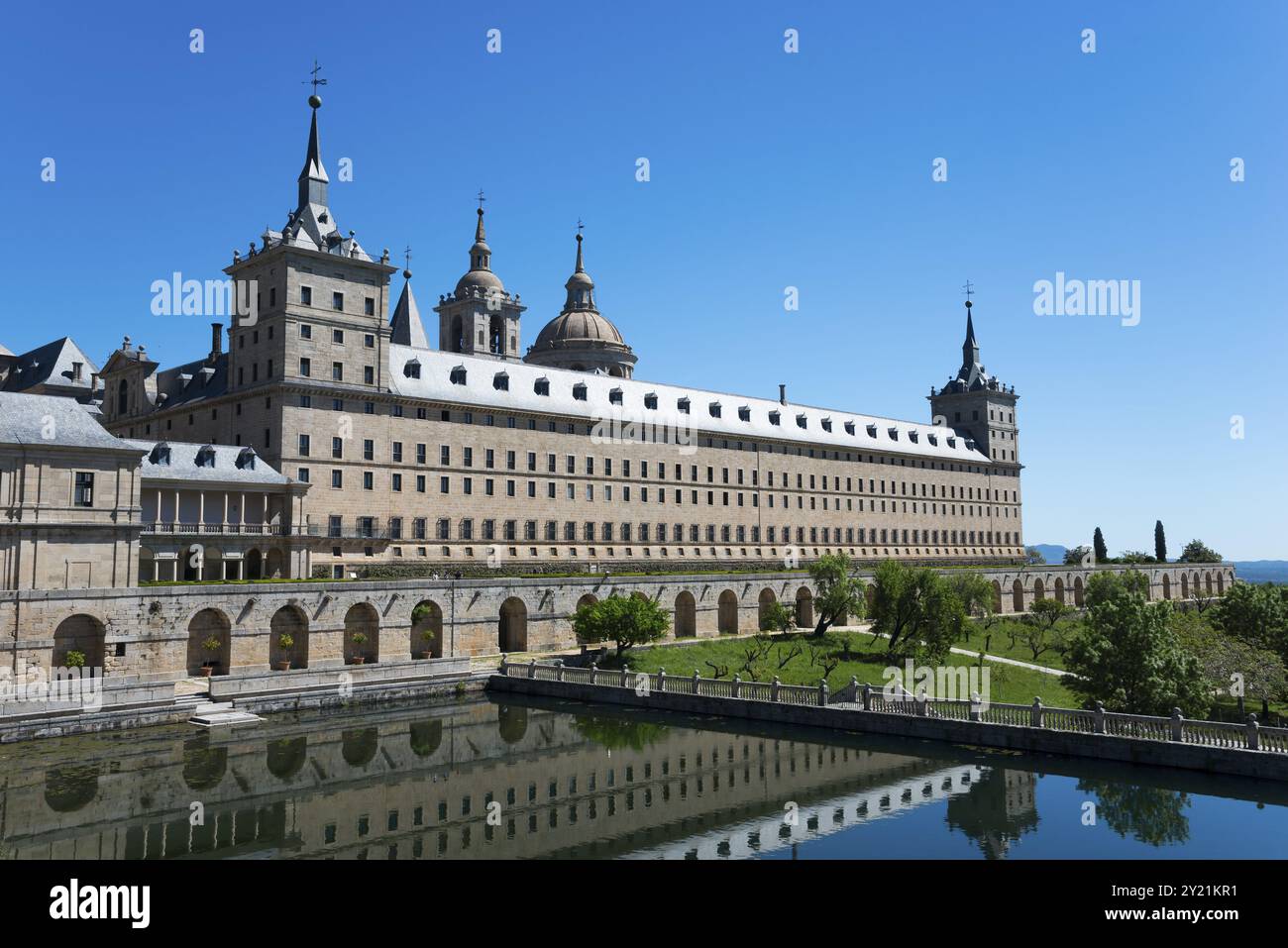 Historic stone monastery with reflection in the water and clear sky ...