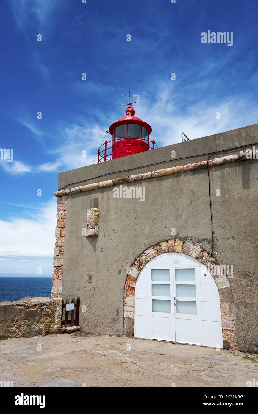 Round red lighthouse on a beige building with stone accents and blue ...