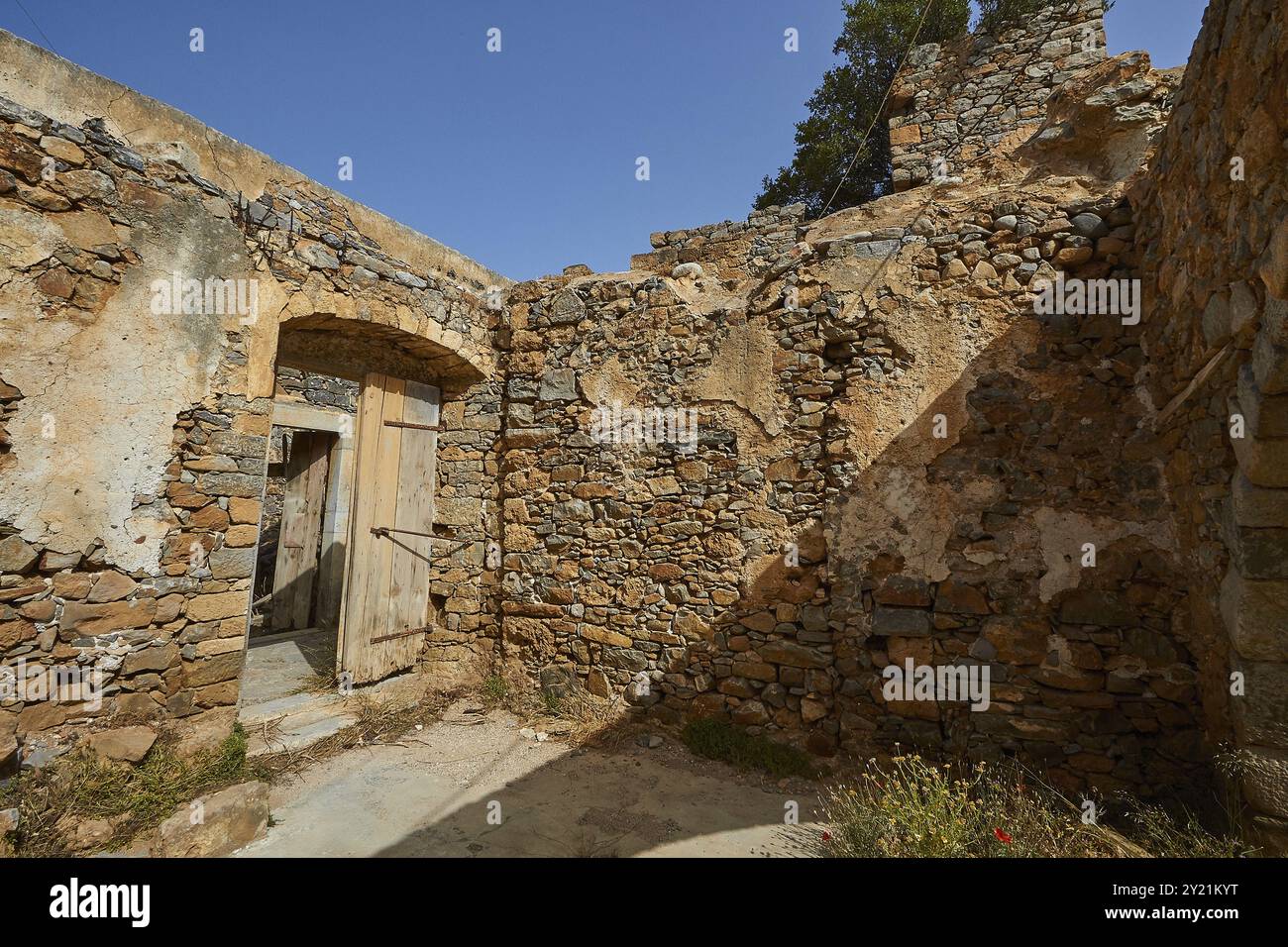A crumbling building with open doors and stone walls standing in ...