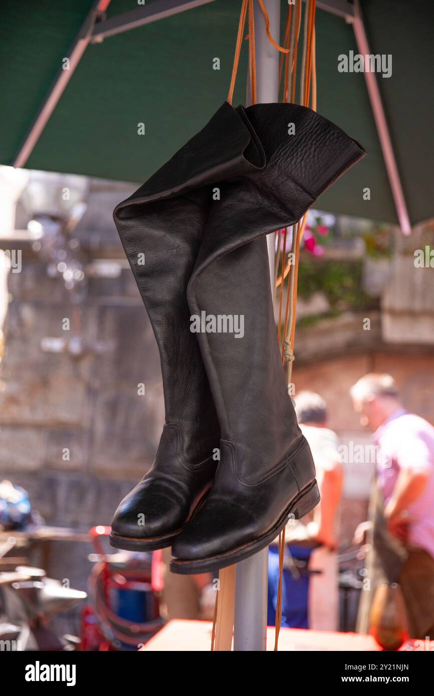 Black leather boots hanging at outdoor flea market, displayed boots ...