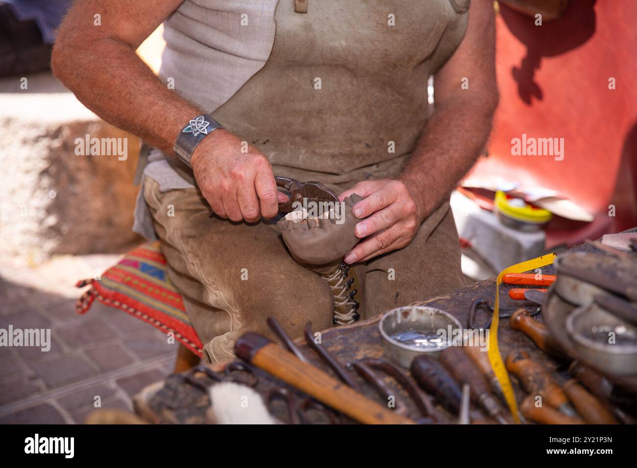 Craftsman stitching leather, shoemaker working with tools, artisan ...