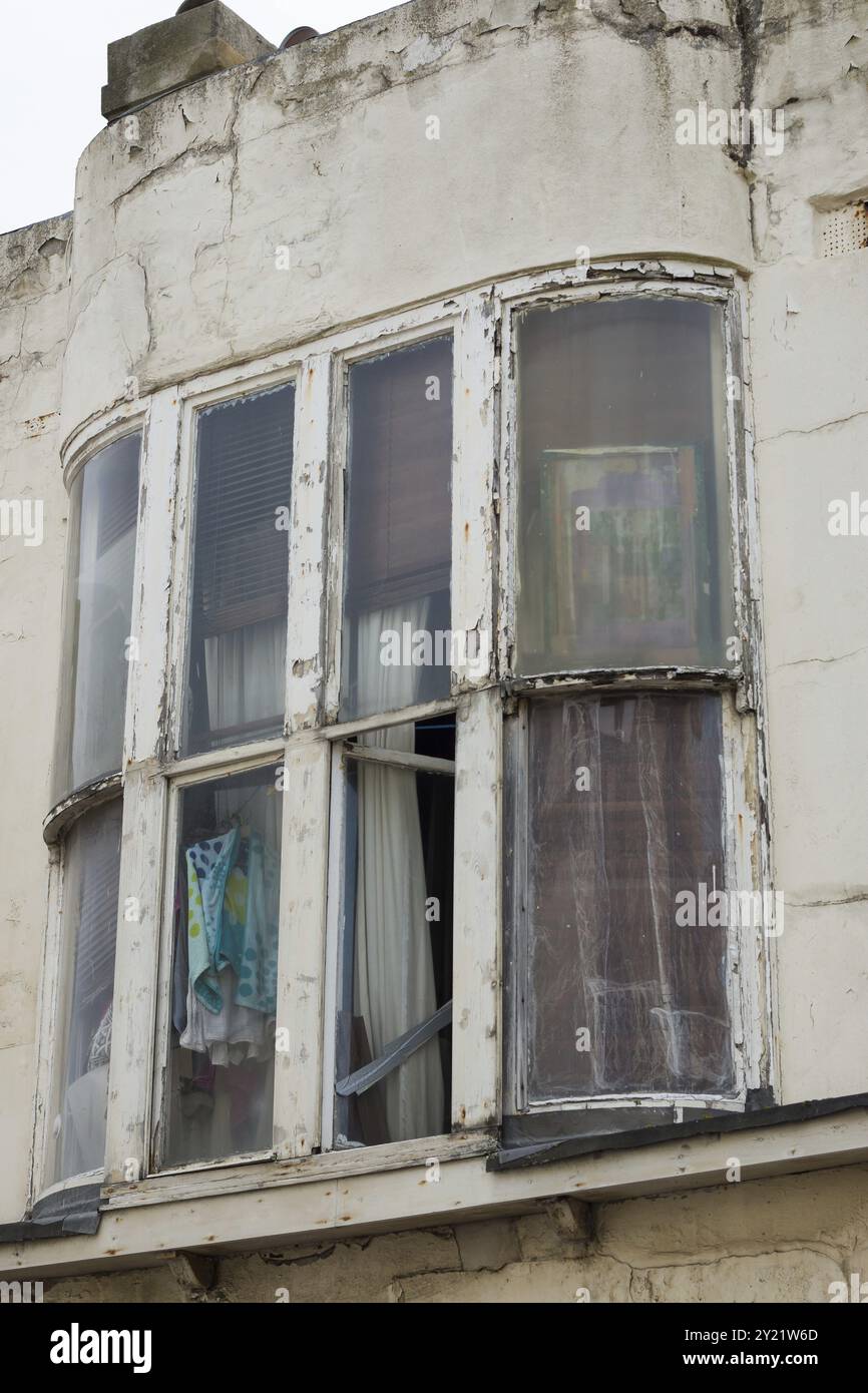Neglected building with structural damage and broken window. View of ...