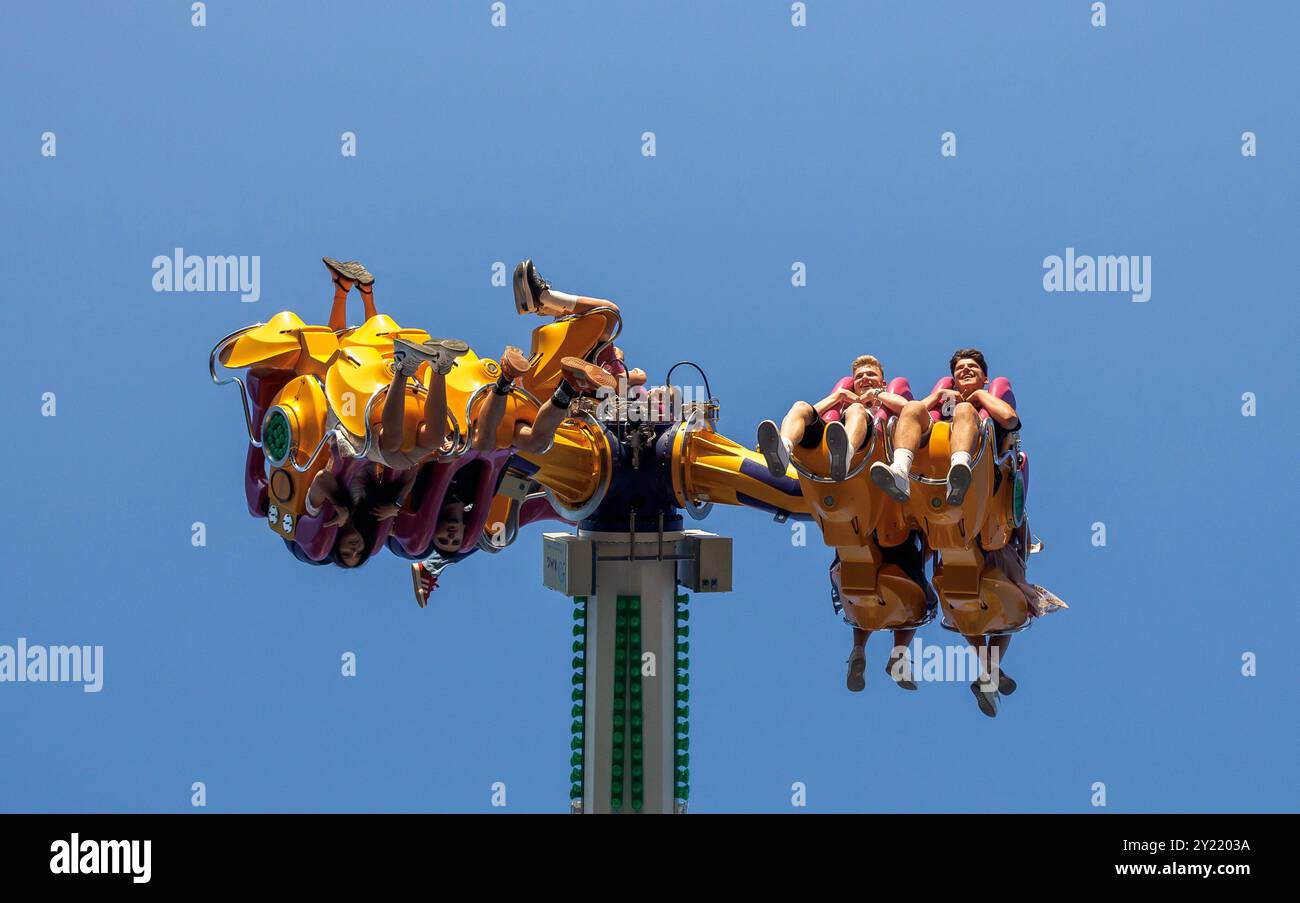 People enjoying amusement park attraction, thrilling ride experience ...