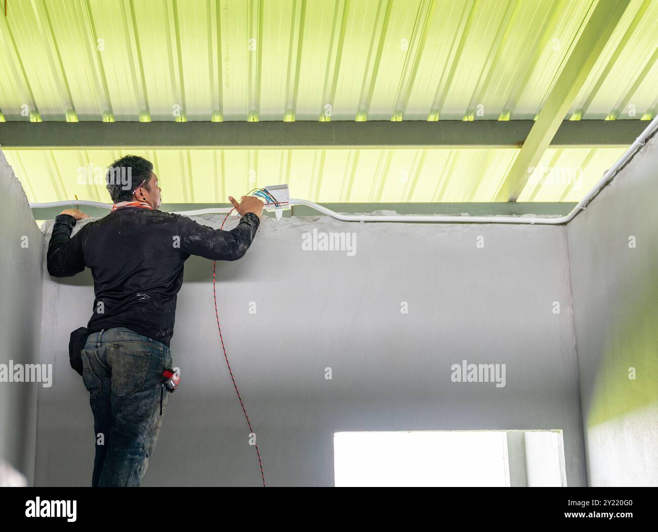 Technician pull wires through conduit in building site Stock Photo - Alamy