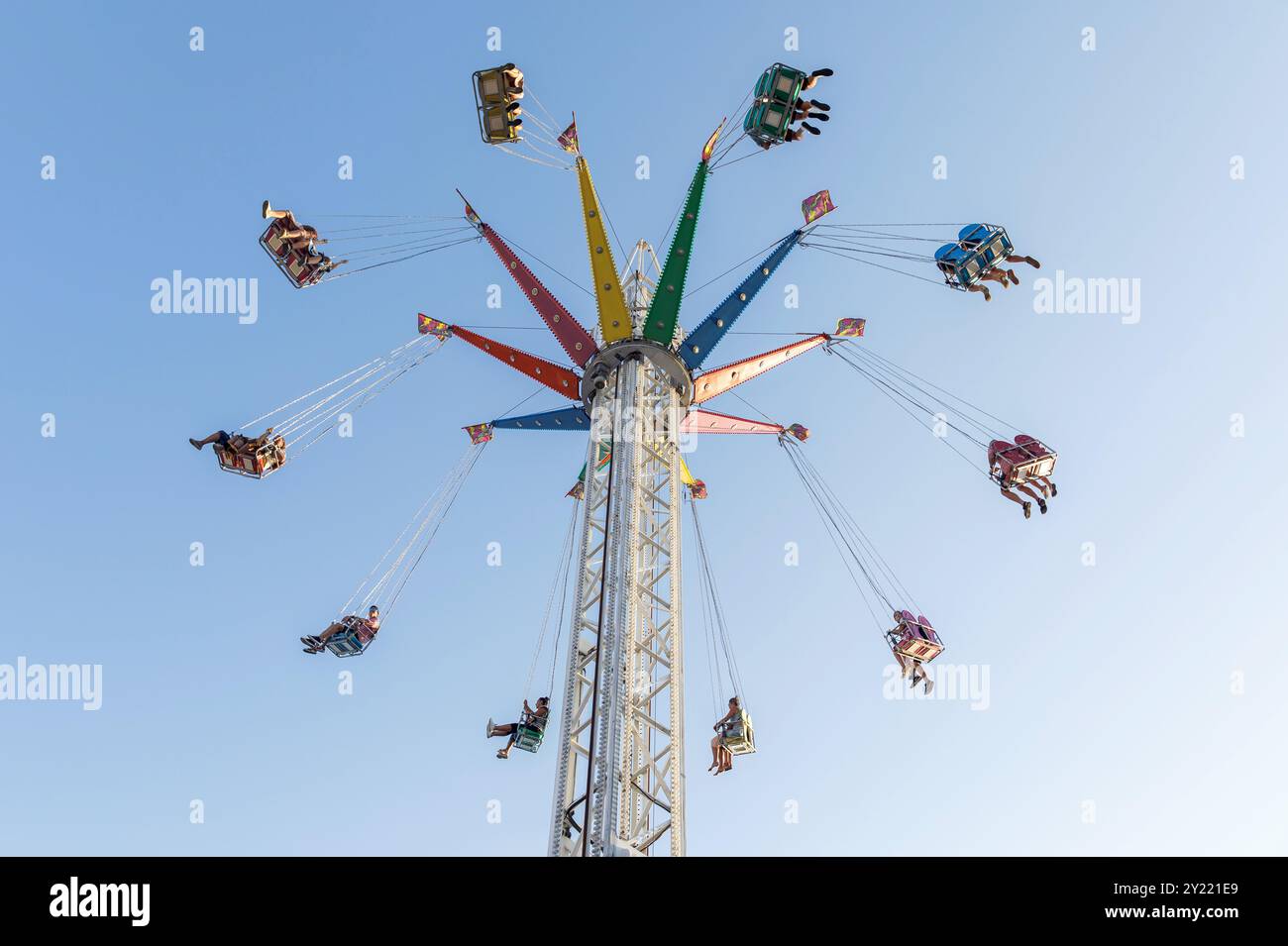 Swing ride at an amusement park, tall and colorful attraction spinning ...