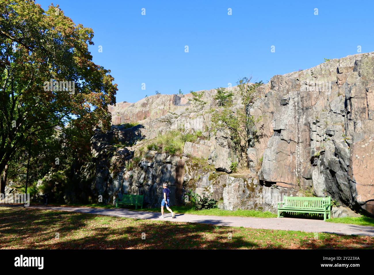 A bench under rock formations in Kaivopuisto park in southern part of ...