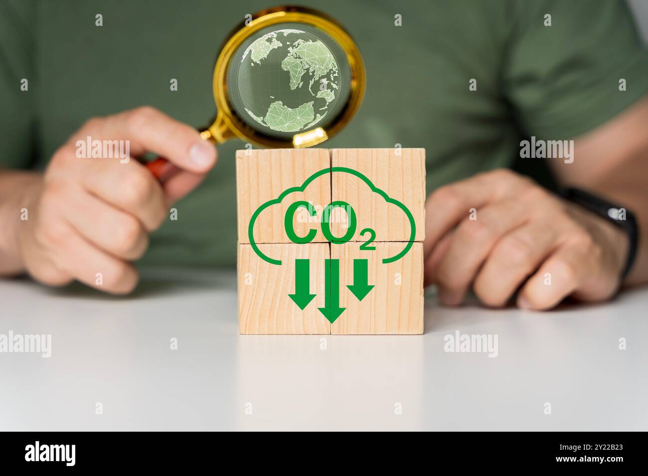 Hand assemble CO2 reducing icon on wooden block cube on nature for ...