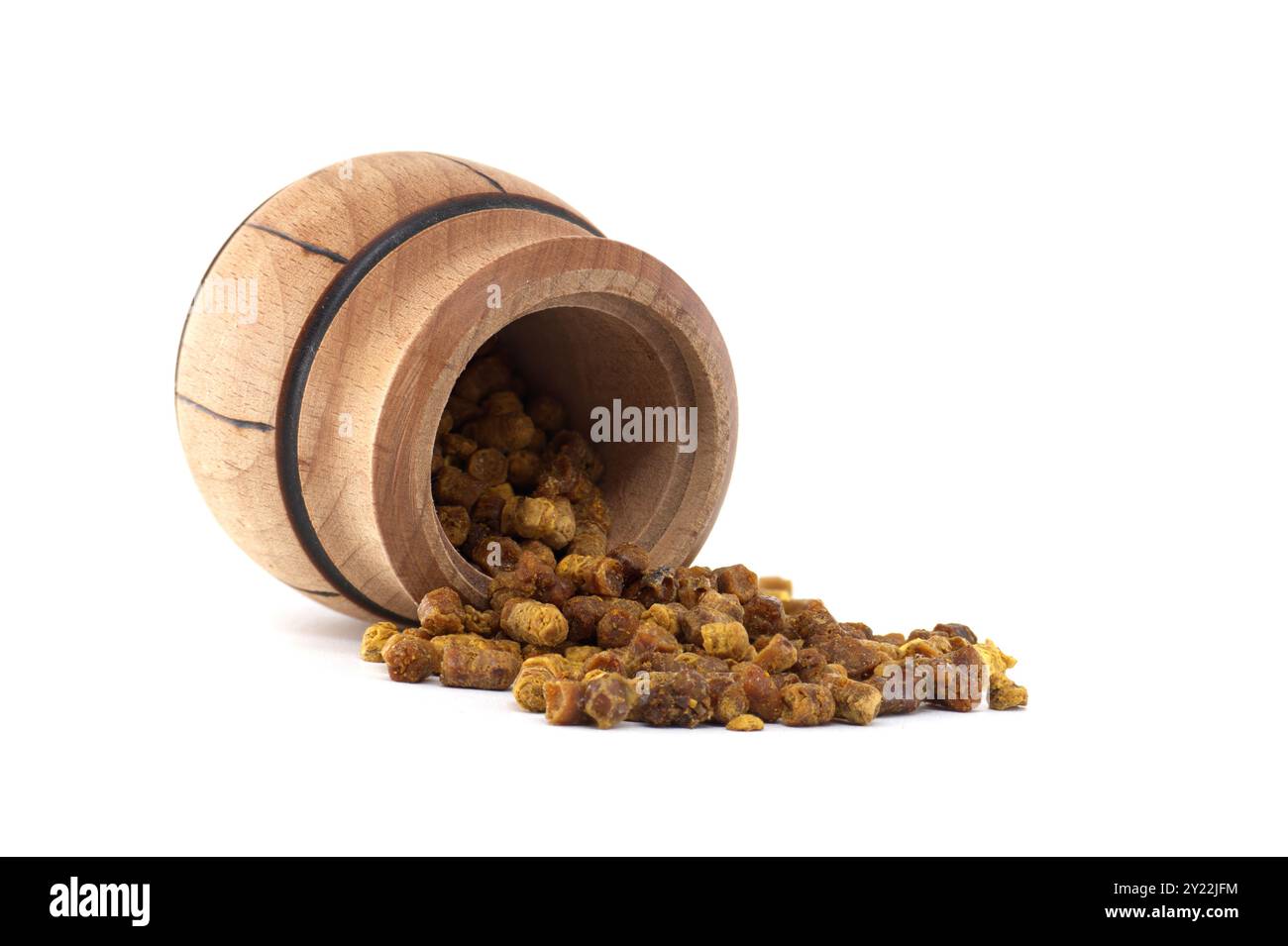 Natural bee bread scattered from a wooden barrel, highlighting a ...