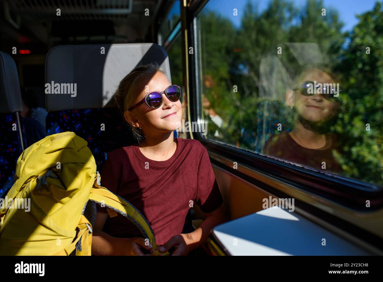 Girl sitting in train, looking out of window and enjoying journey ...