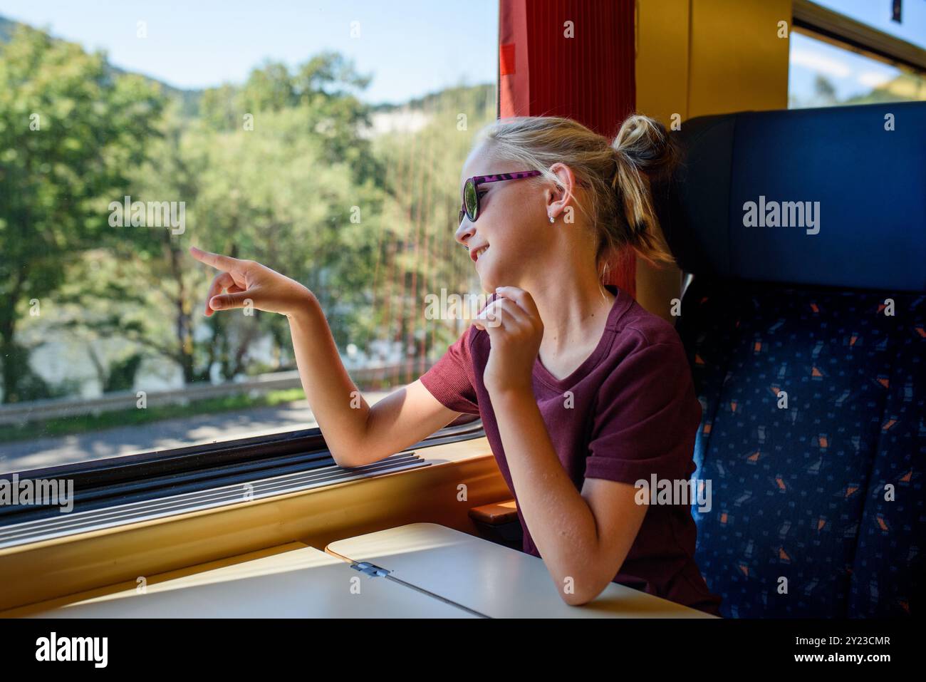 Girl sitting in train, looking out of window and enjoying journey ...