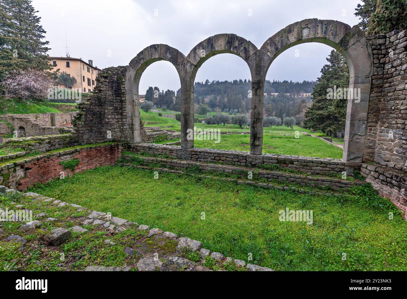 Ancient Roman ruins in Fiesole, Italy, featuring stone arches and lush ...