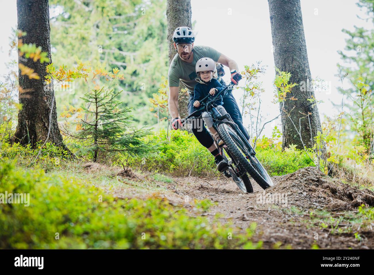 Front mounted child shotgun seat used for mountain bike. MTB front seat for kids, in forest ...