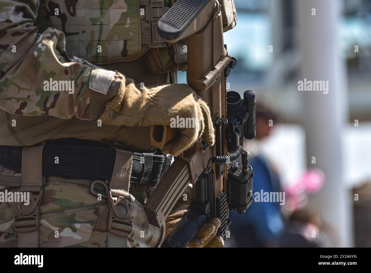 Soldier is holding a modern assault rifle with a scope and tactical ...