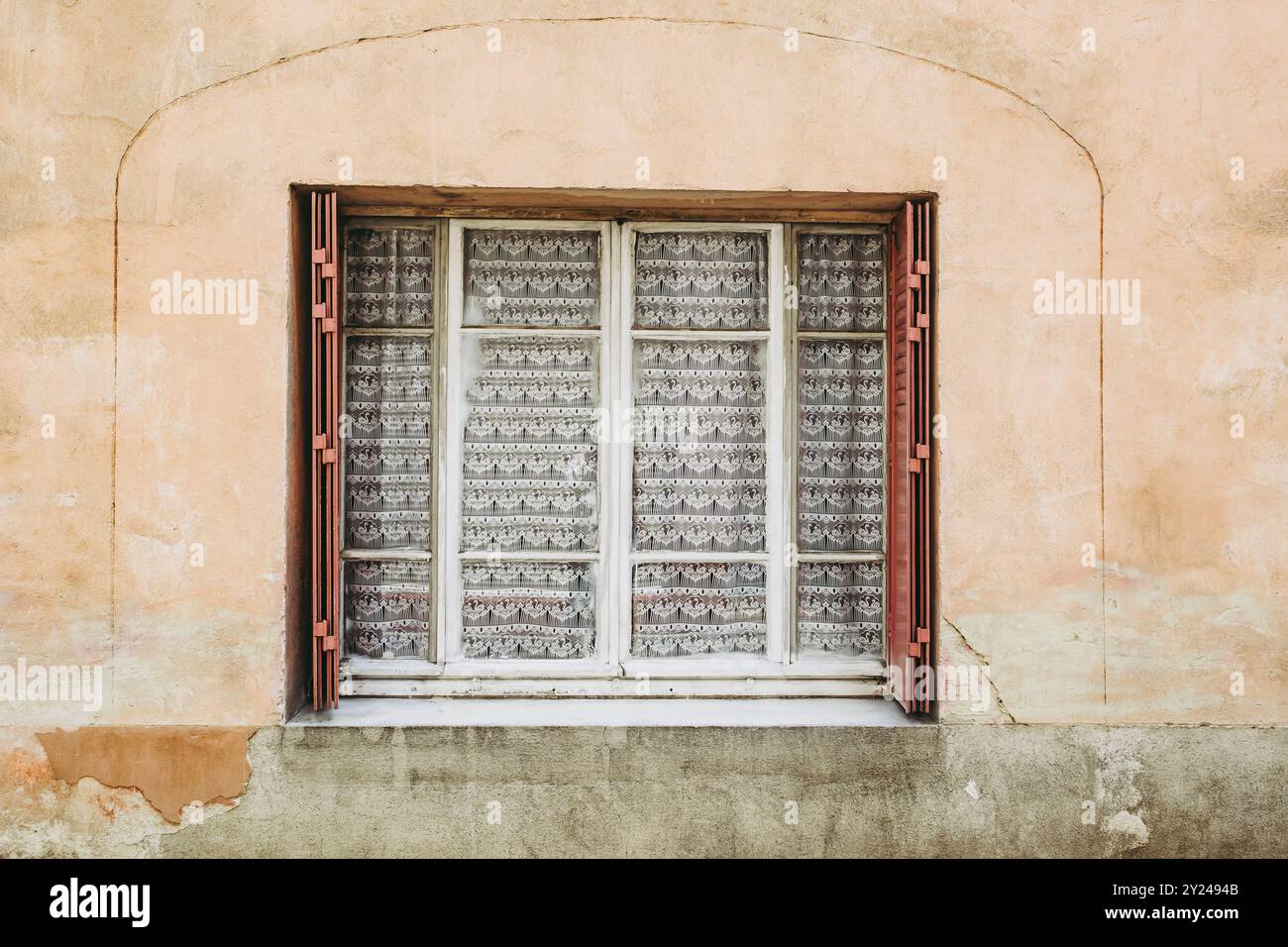 Old house window with vintage white lace curtains and salmon colored ...