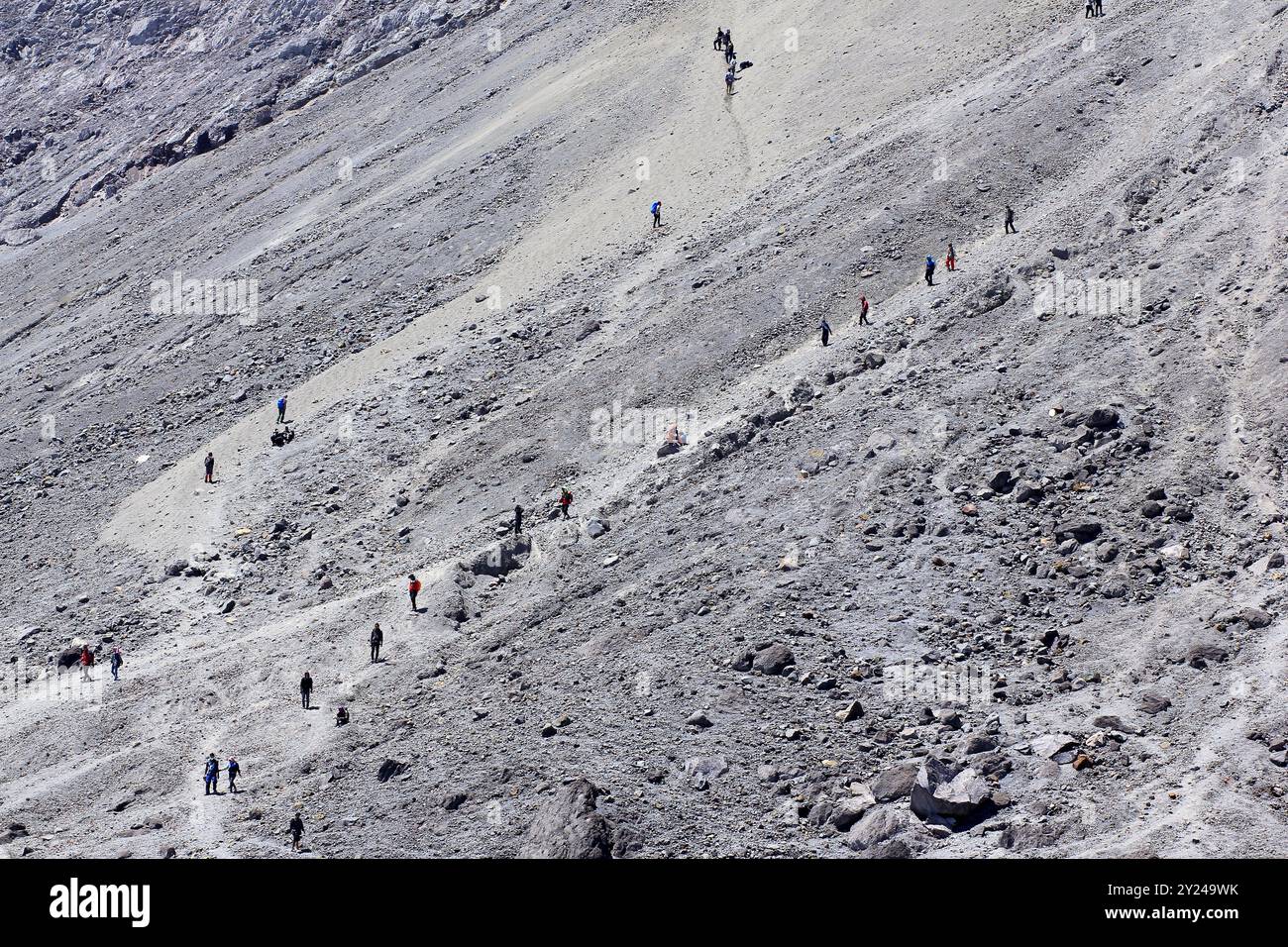 Climbers pass the sandy climbing route to the top of Mount Merapi, with ...
