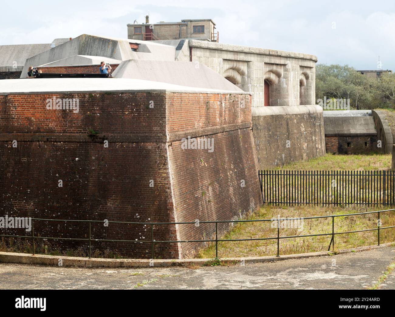 Two people using binoculars standing inside fortress tower wall ...