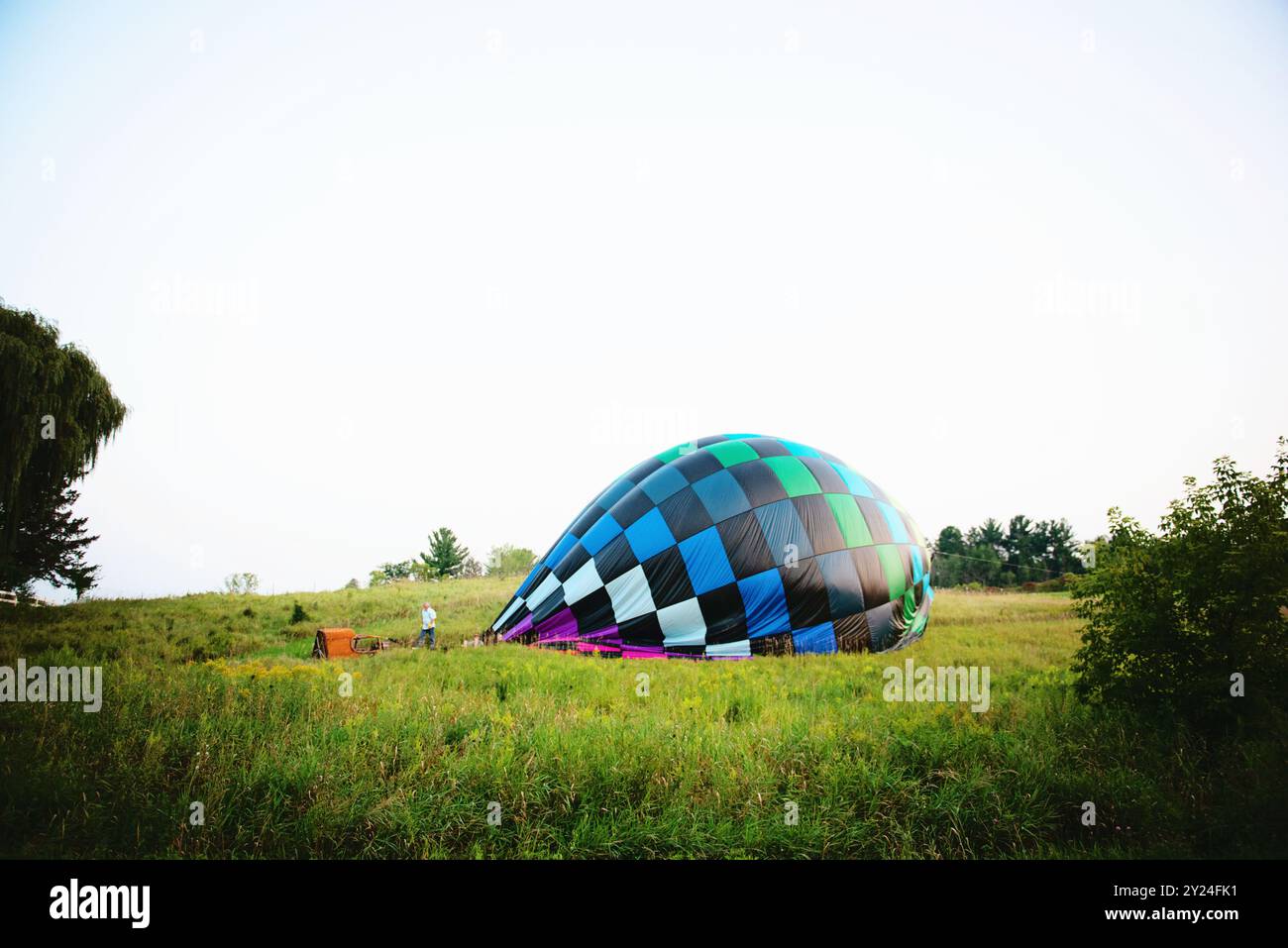 Hot air balloon deflating in a rural field Stock Photo - Alamy