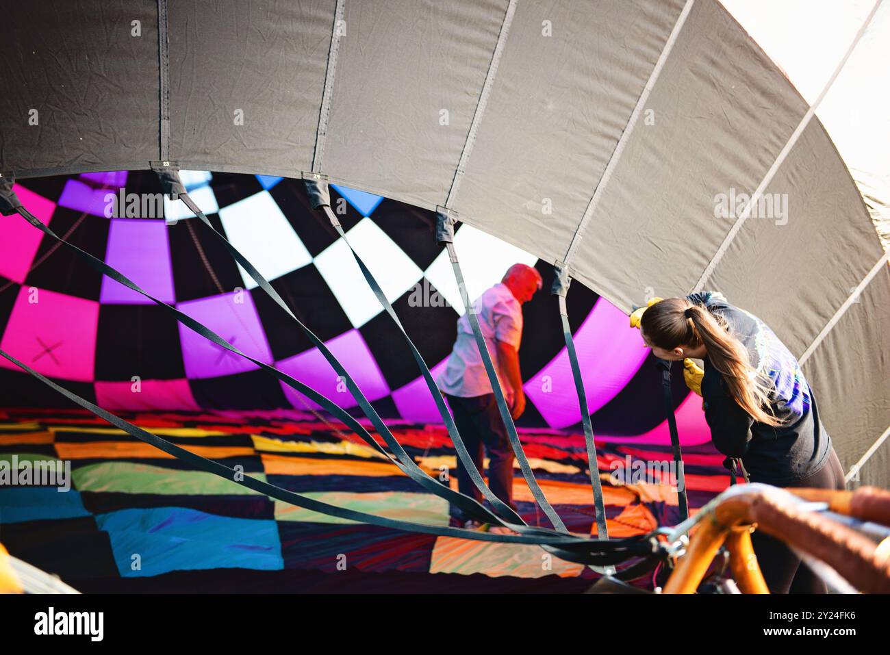 Man inside the envelope of a hot air balloon being filled Stock Photo ...