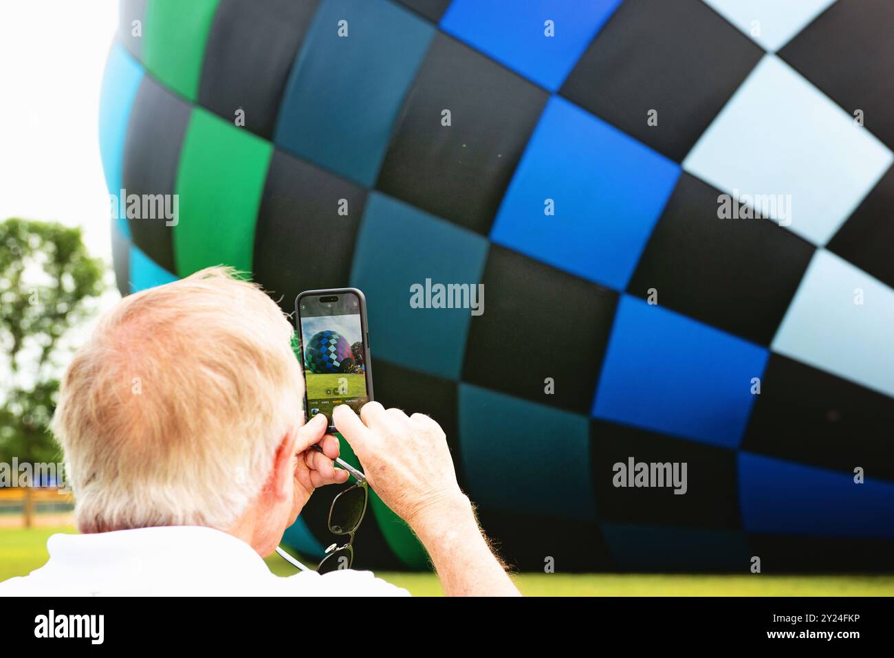 Man taking a picture of a hot air balloon inflating Stock Photo - Alamy