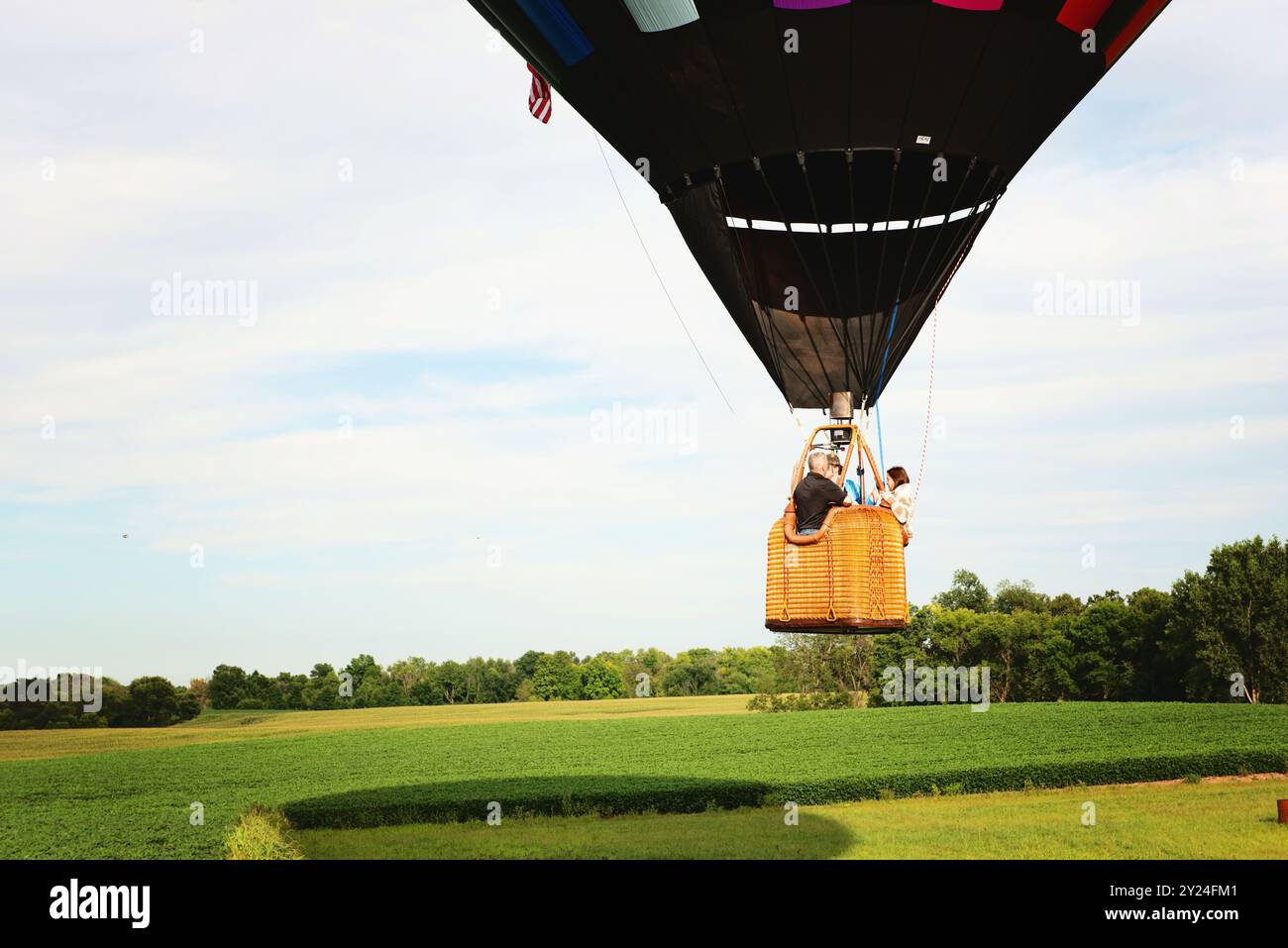 Hot air balloon landing in a country field Stock Photo - Alamy