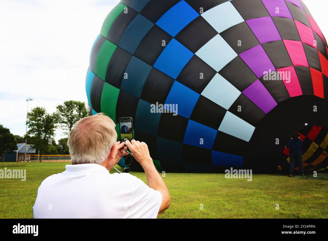 Man taking picture of a hot air balloon inflating Stock Photo - Alamy