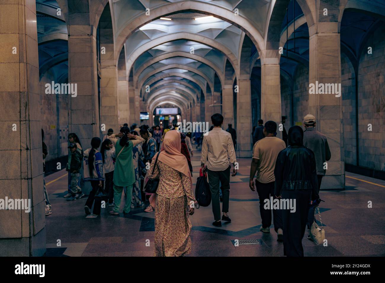 A group of people are walking down a long hallway Stock Photo - Alamy