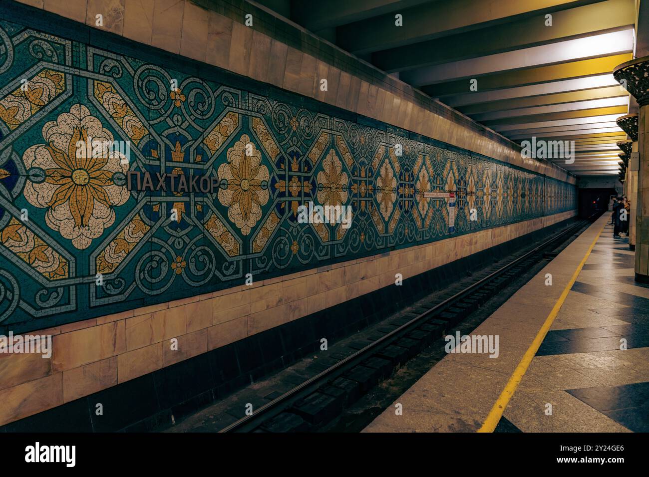 A long train station with a blue and gold wall Stock Photo - Alamy