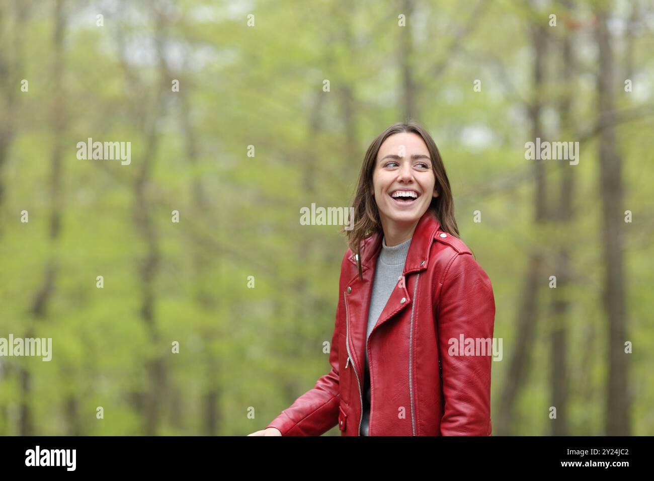 Happy casual woman laughing standing in a forest hi-res stock ...