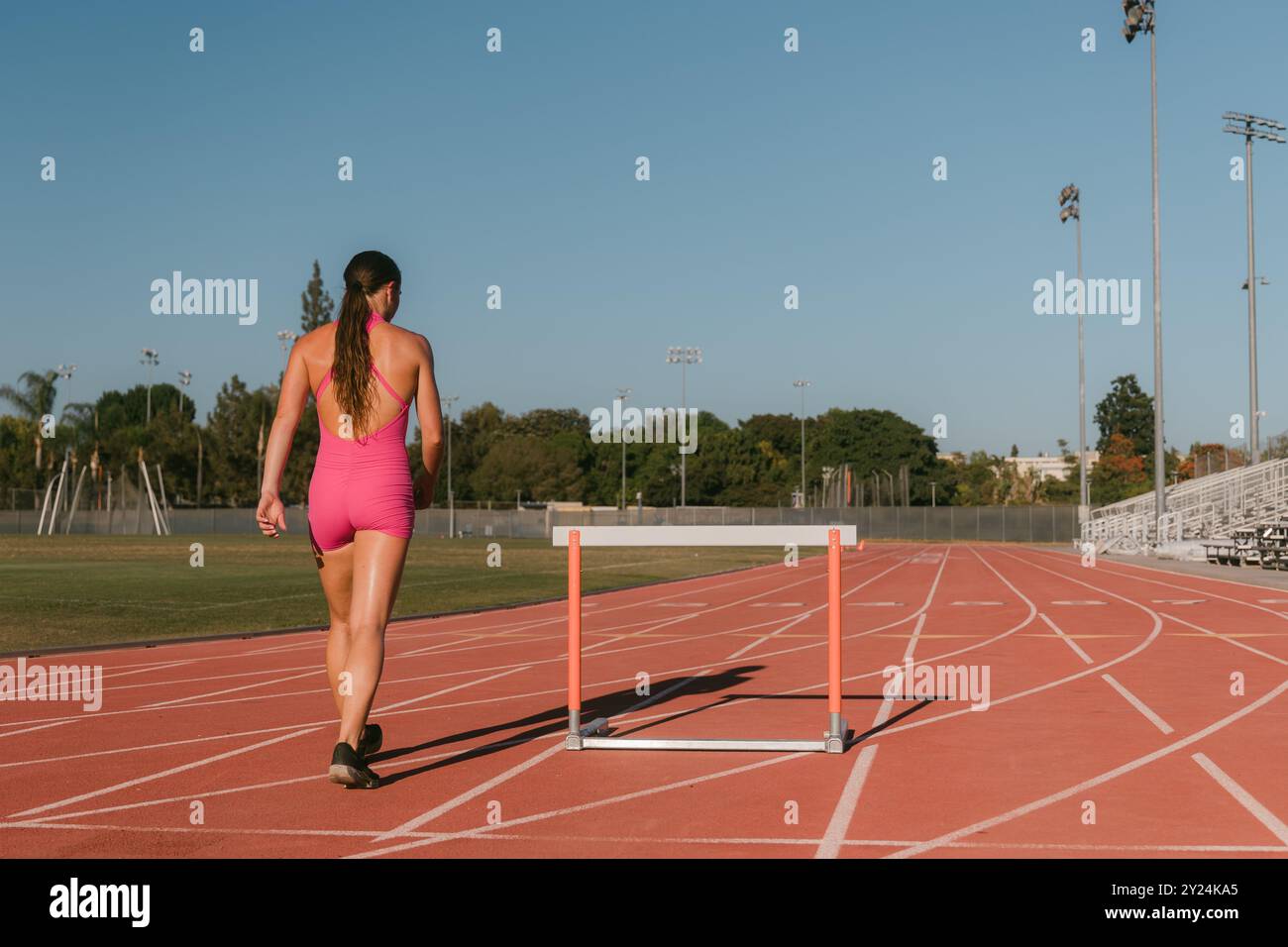 Female athlete walking back from hurdle drill Stock Photo - Alamy