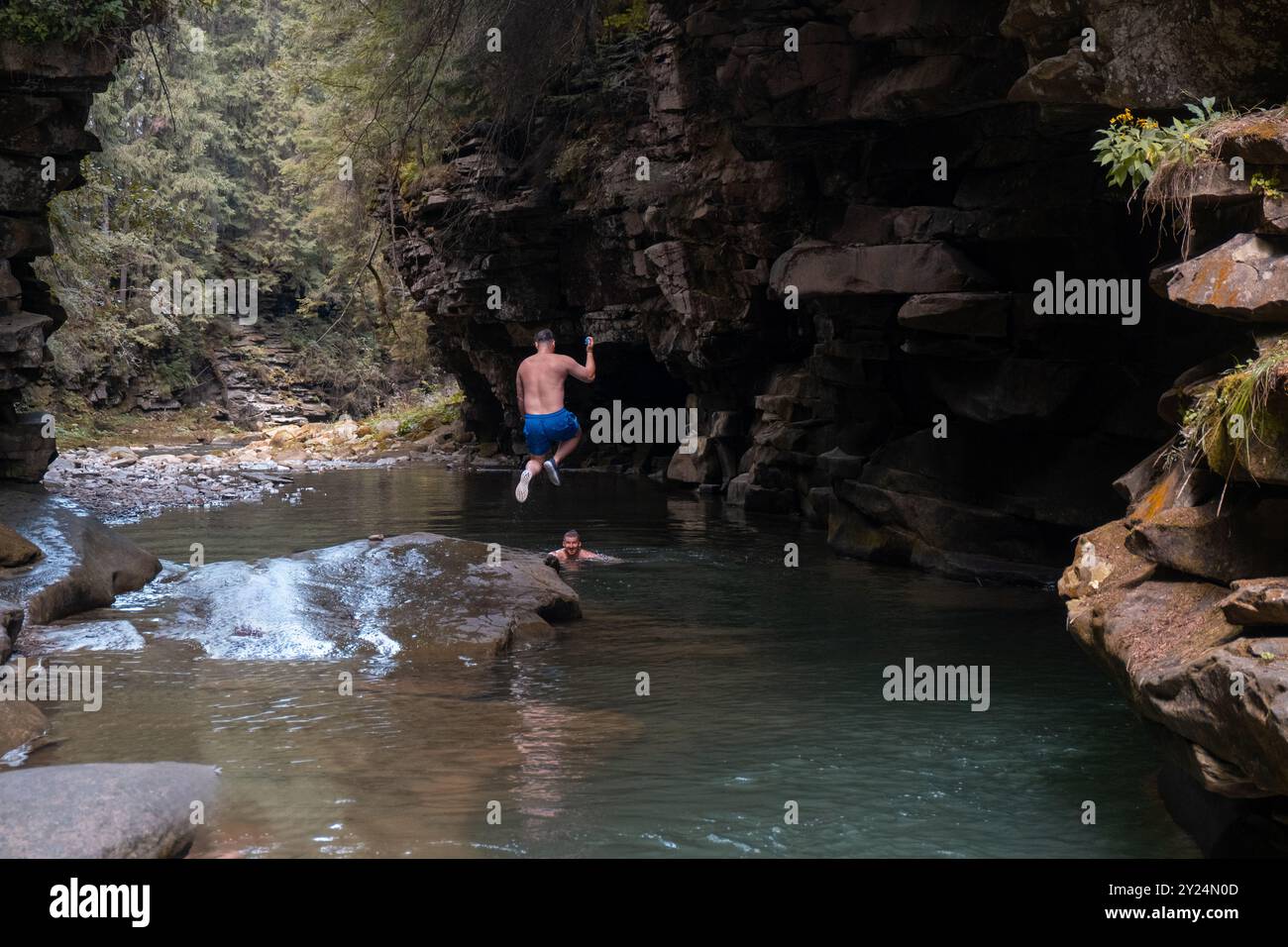 Man Jumping into Serene River Stock Photo - Alamy