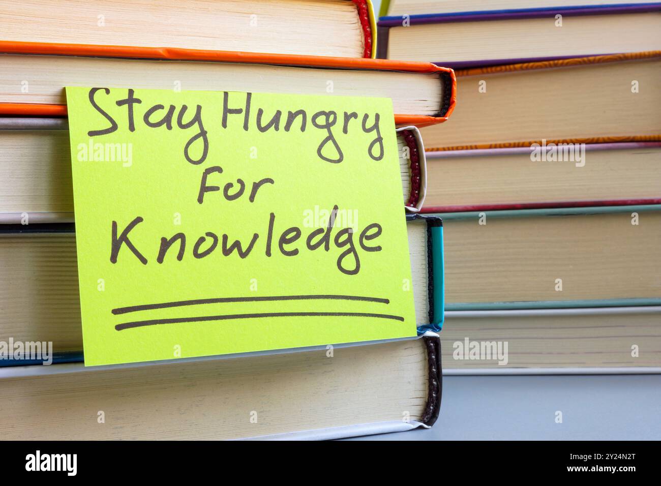 Stack of books with stay hungry for knowledge note as a symbol of ...