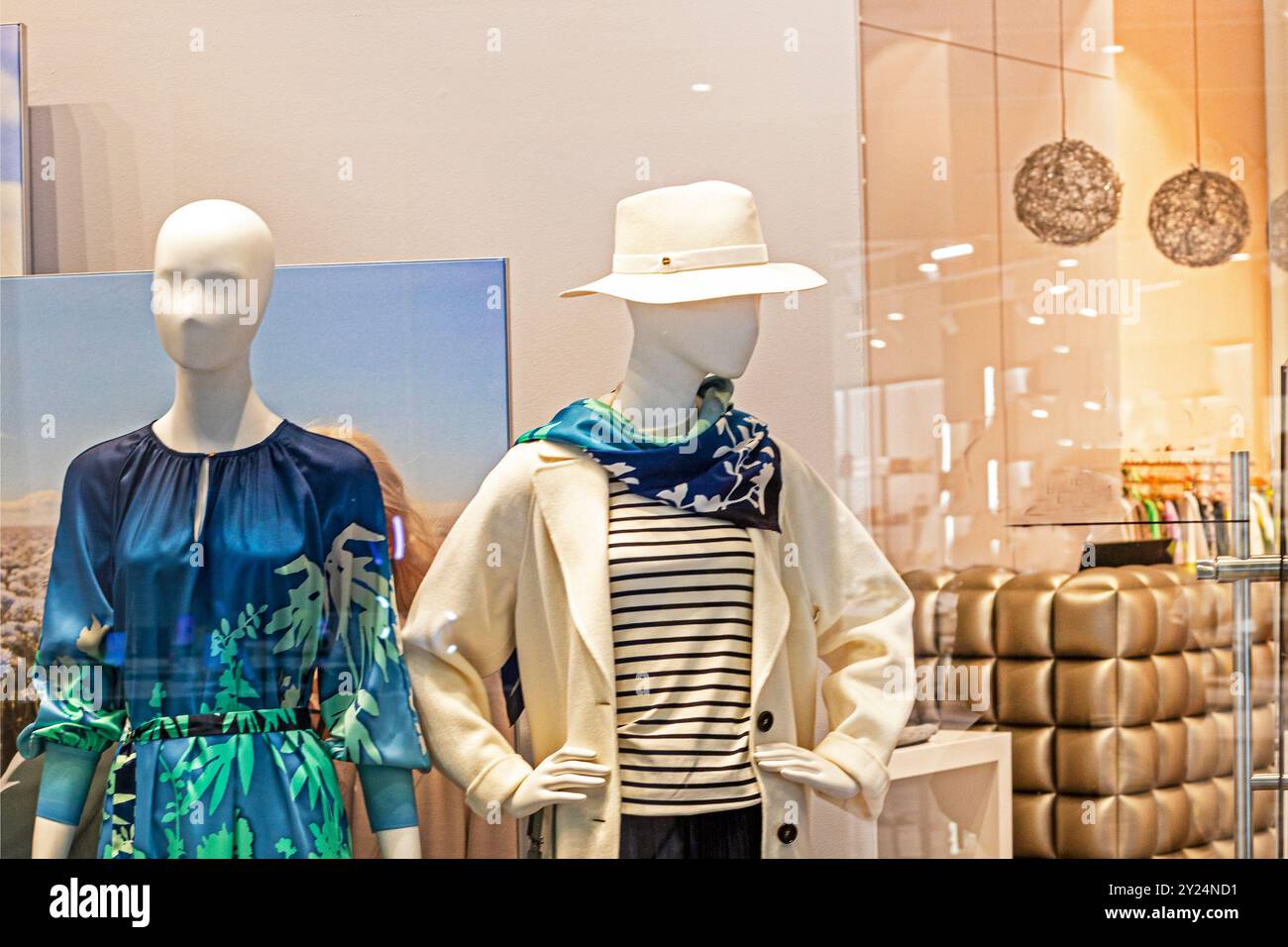 female mannequins in stylish dress in a shop window with clothes ...