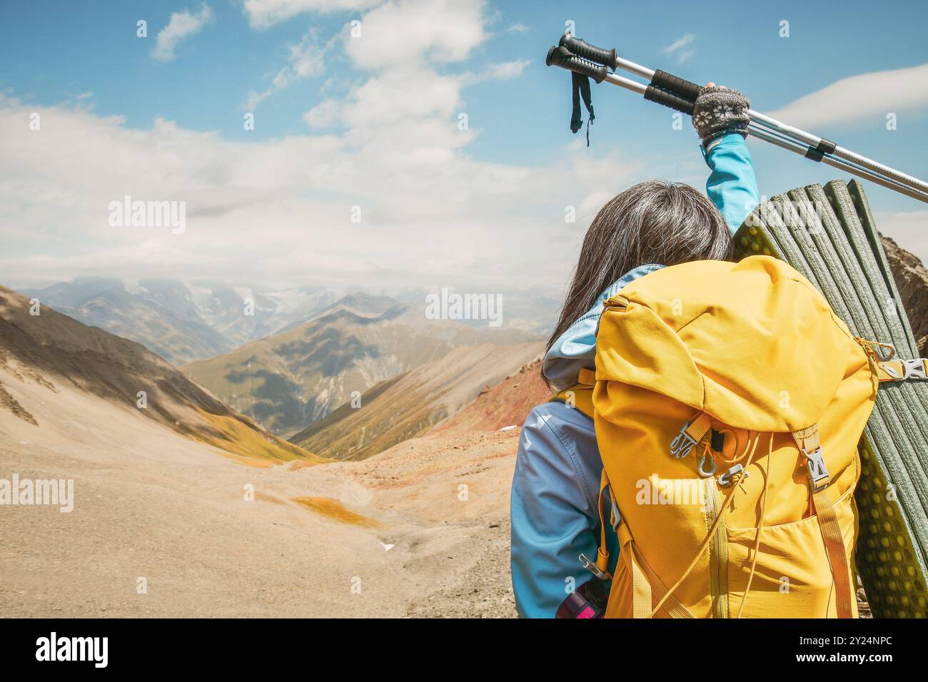 Close up Woman look to mountains panorama back view hold poles up pose ...
