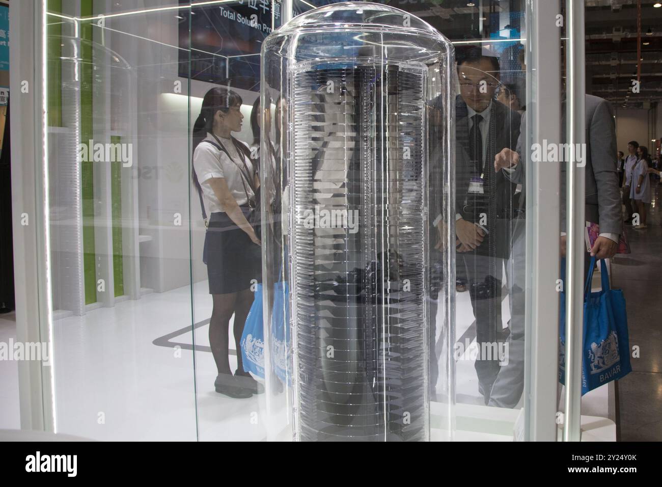 Visitors watch various silicon wafers on display during the SEMICON ...