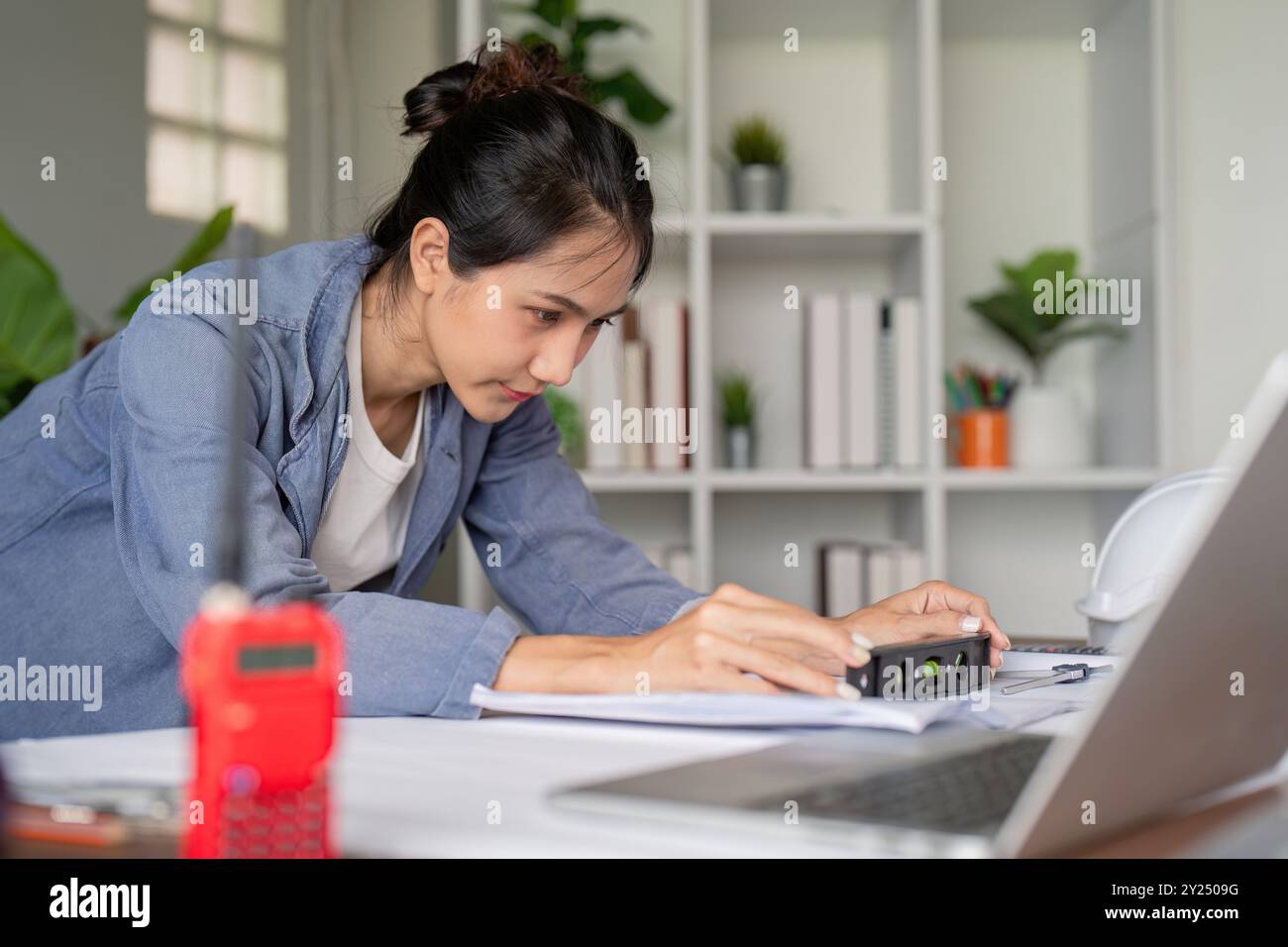 Engineer measuring blueprints with precision tool in office Stock Photo ...