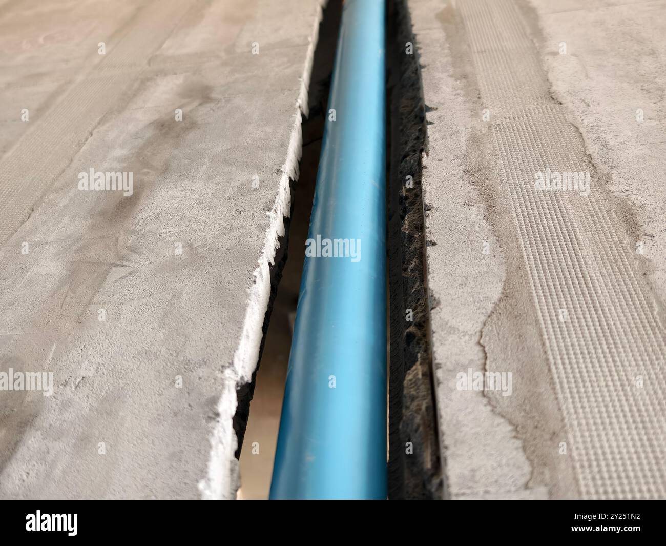 A bright blue pipes attached to a solid concrete wall Stock Photo - Alamy