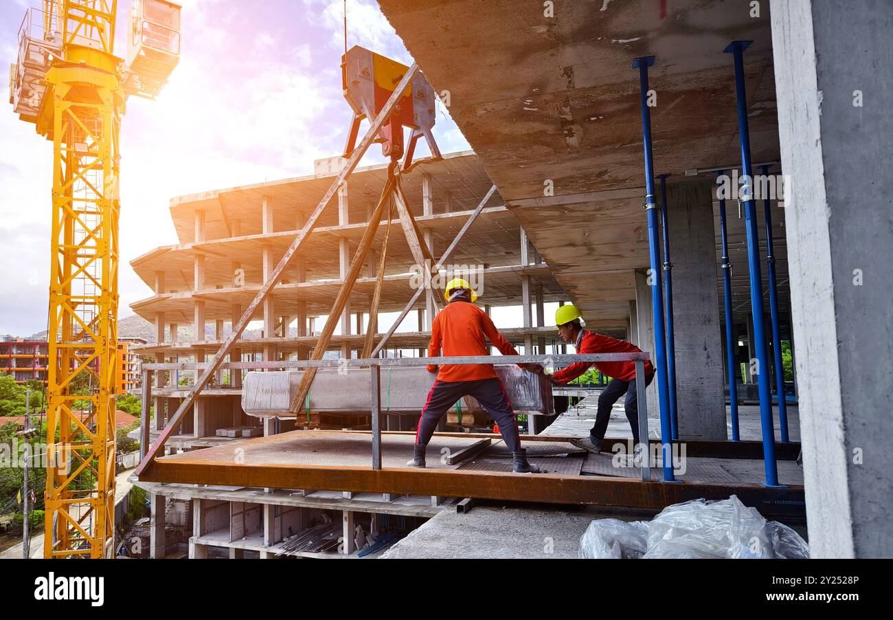 Workers at a building under construction take slabs from a crane Stock ...