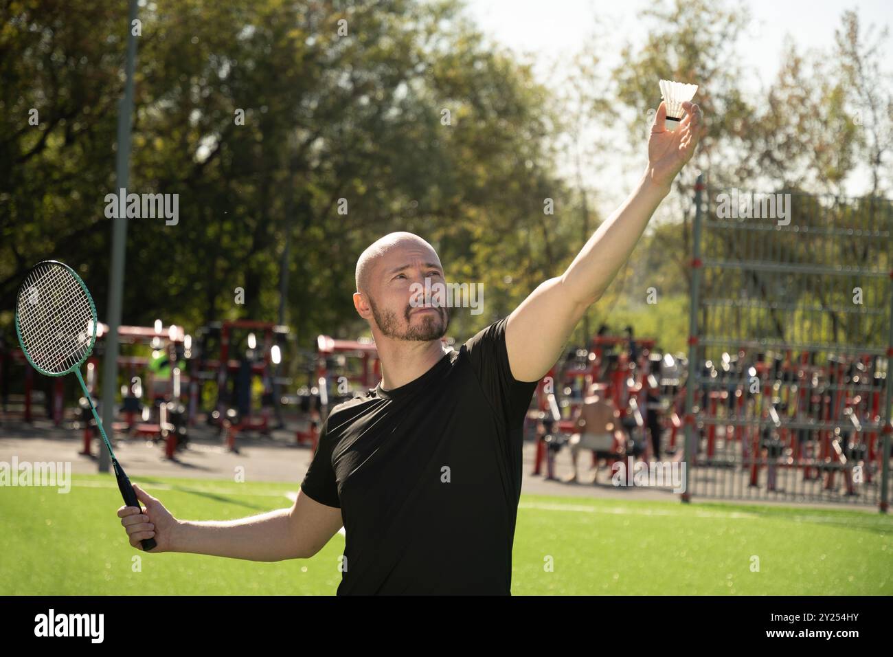 Man playing badminton on floor sport court in public park. Outdoors ...