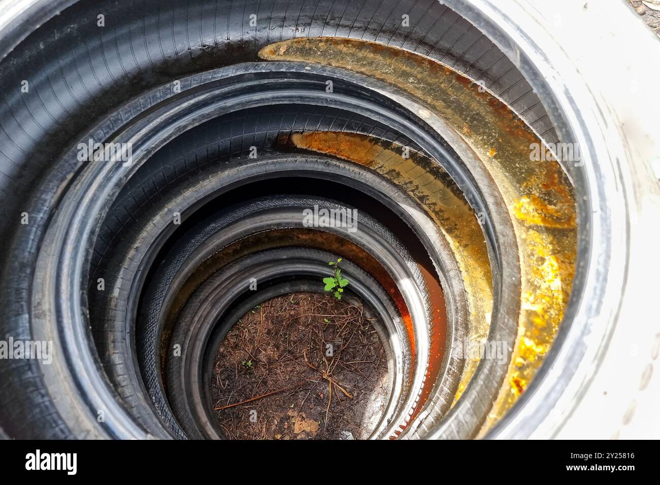 Closeup on stack of old and used tires with rain water and become ...