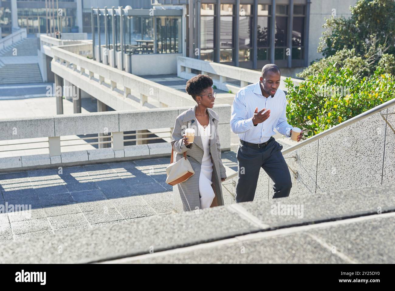 Two Professionals Walking and Talking in Urban Setting Stock Photo - Alamy