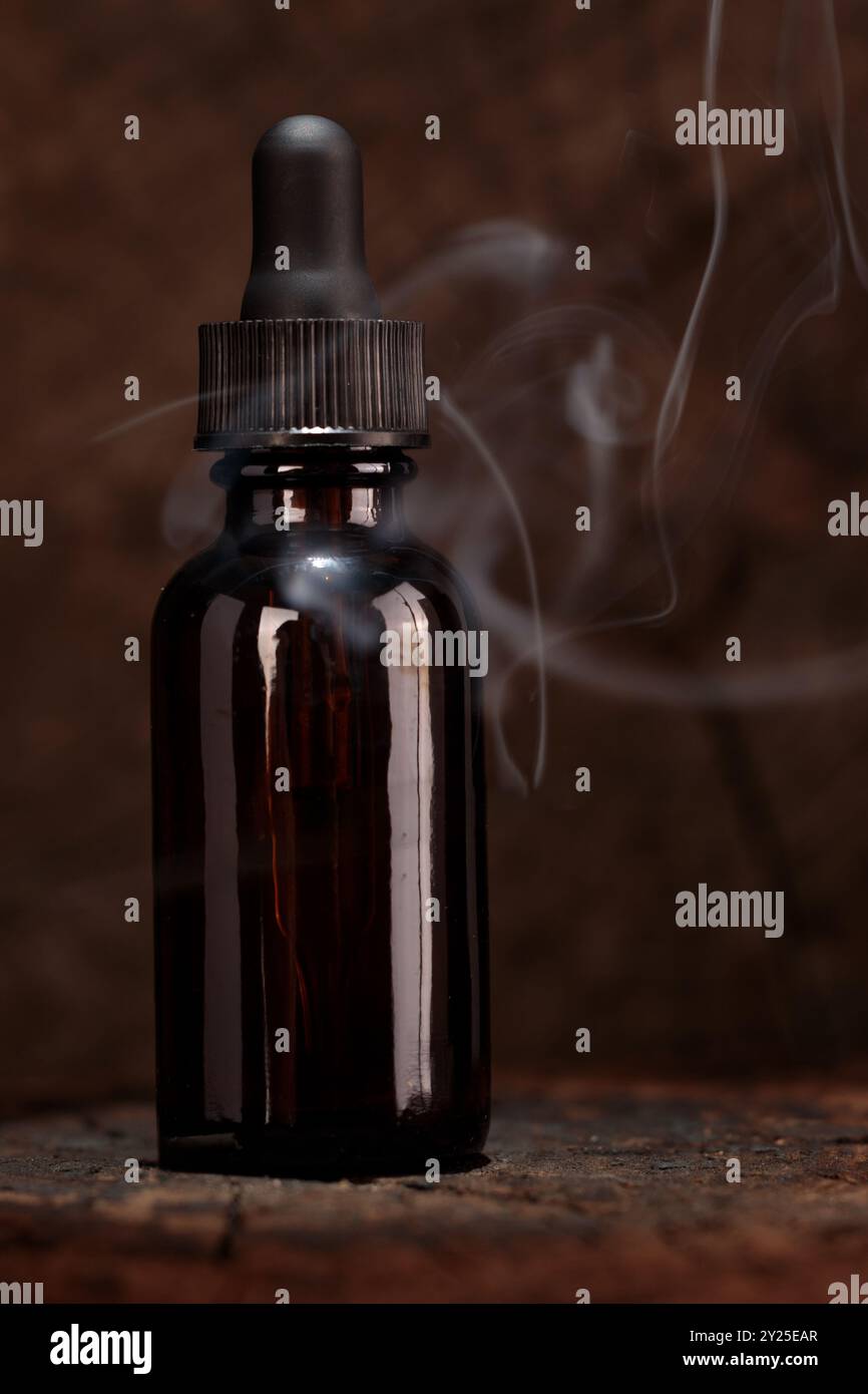 Dark amber dropper bottle with smoke effect Stock Photo - Alamy