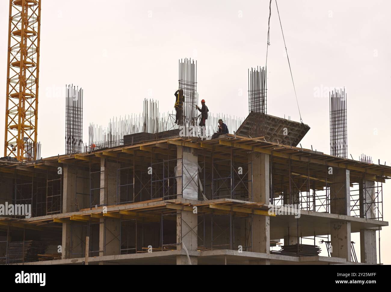 construction workers install metal rebar and build a new high-rise ...